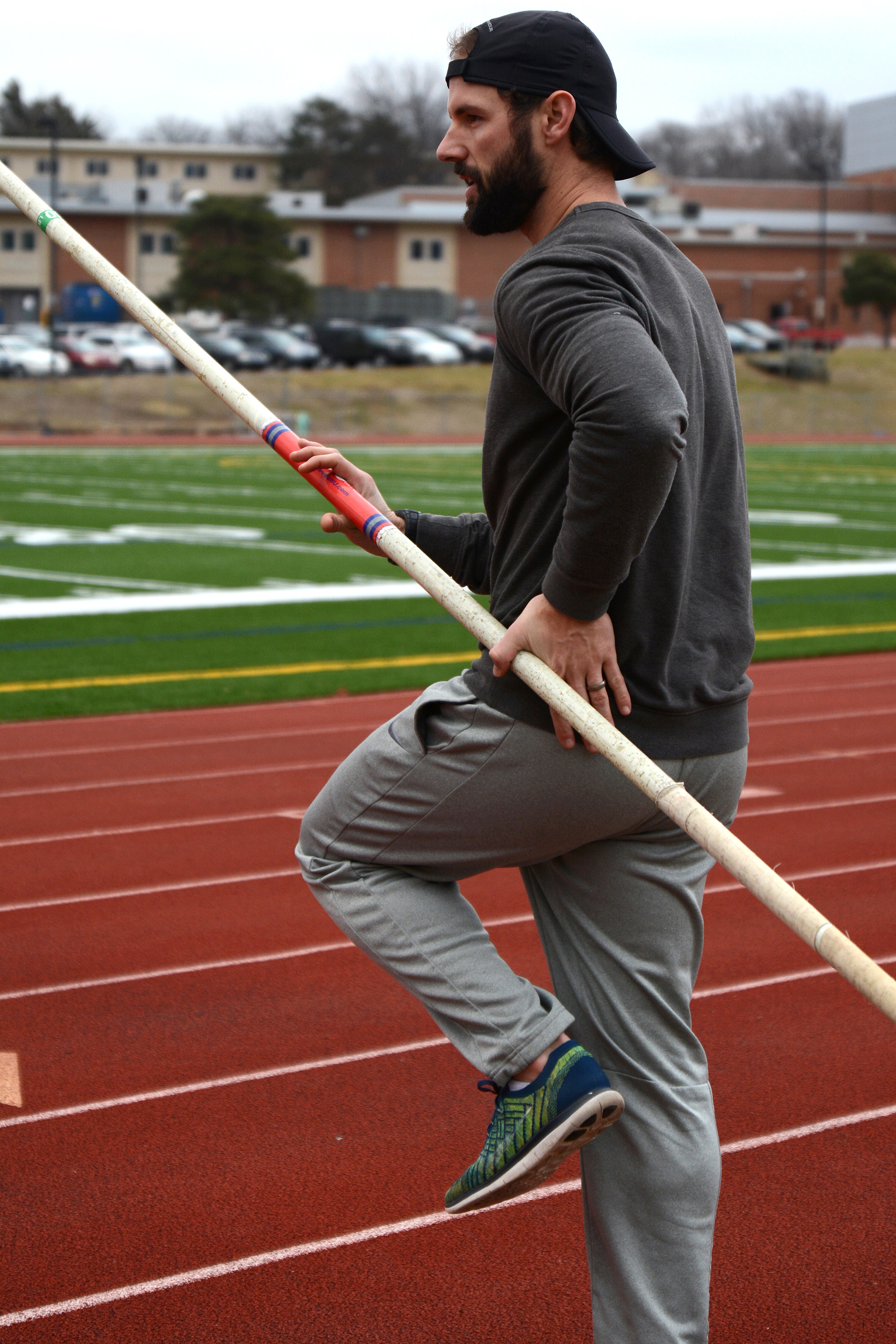 Coach Cooper Merrill demonstrates proper pole vaulting form. Photo by ...