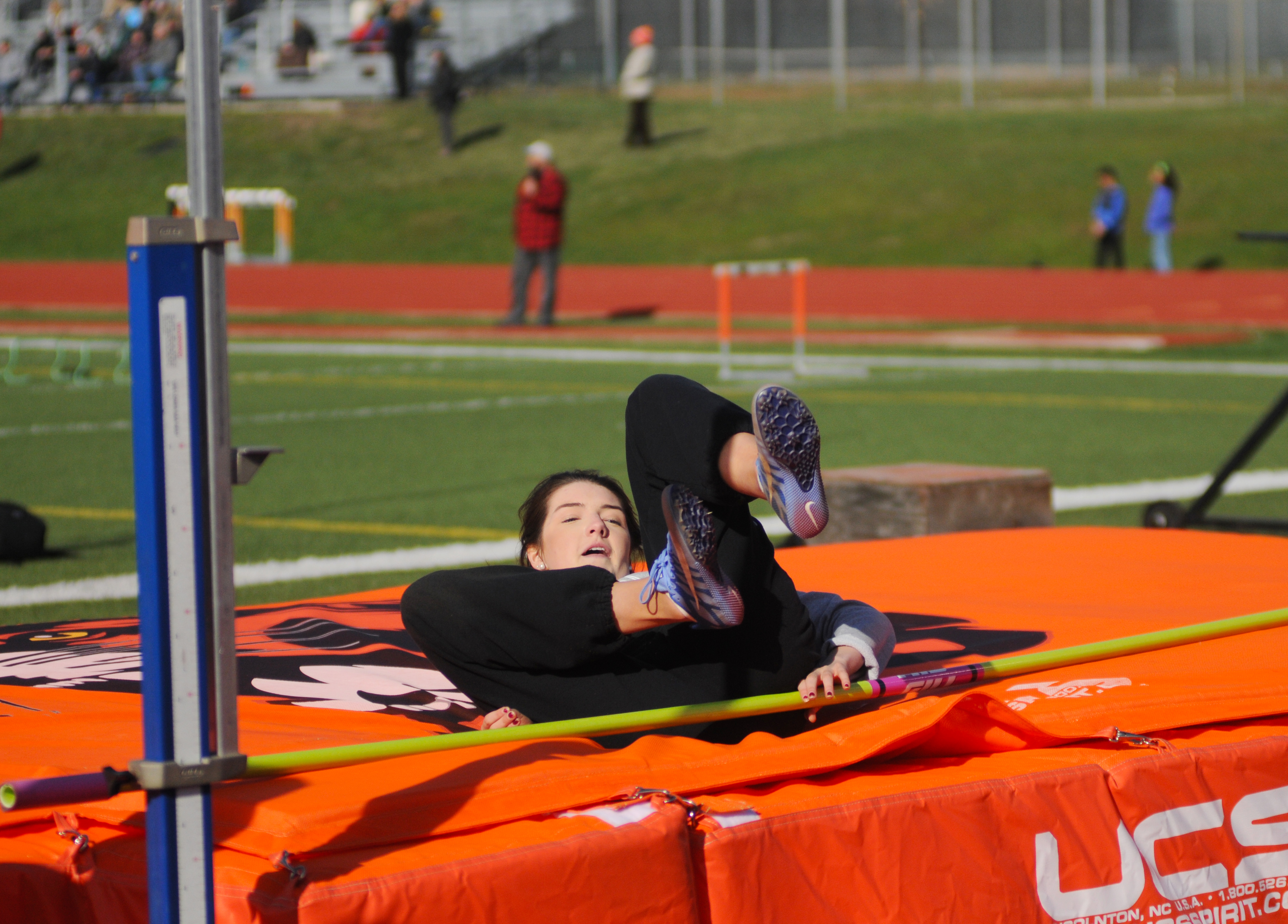 Senior Maddie Smiley looks between her legs to her friends who are ...