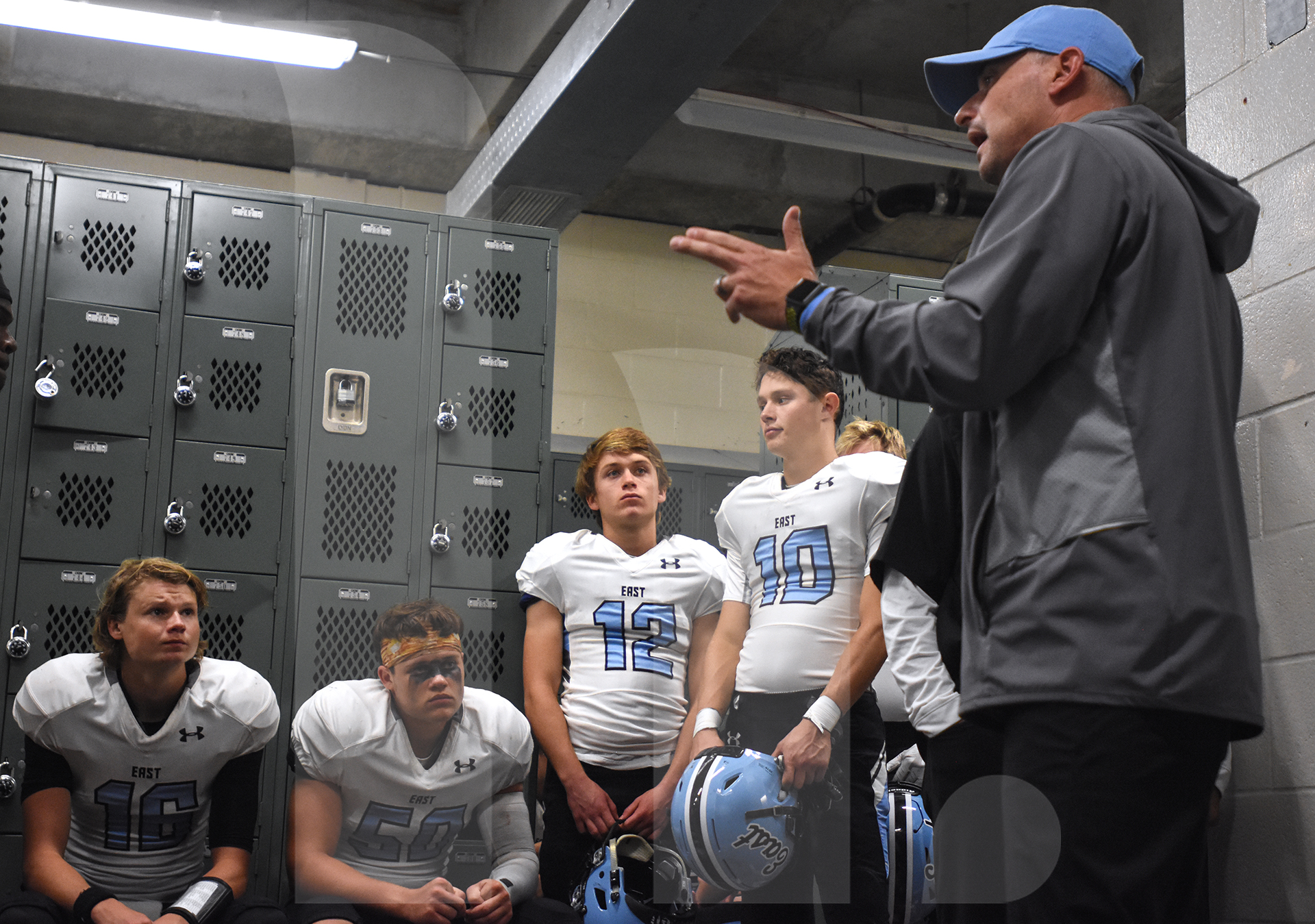 Coach Hoover speaks to the players during halftime in the locker room ...